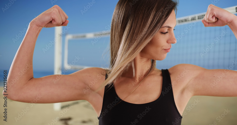 Fit Caucasian girl in her 20s showing off arm muscles by beach ...
