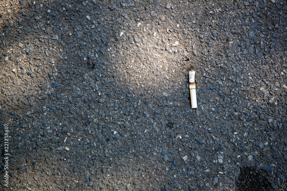 Cigarette butts on the street.Cigarette stub on the floor black ...