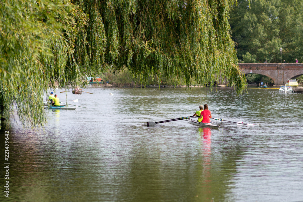 racing boats under willow tree with arched bridge in background Stock ...