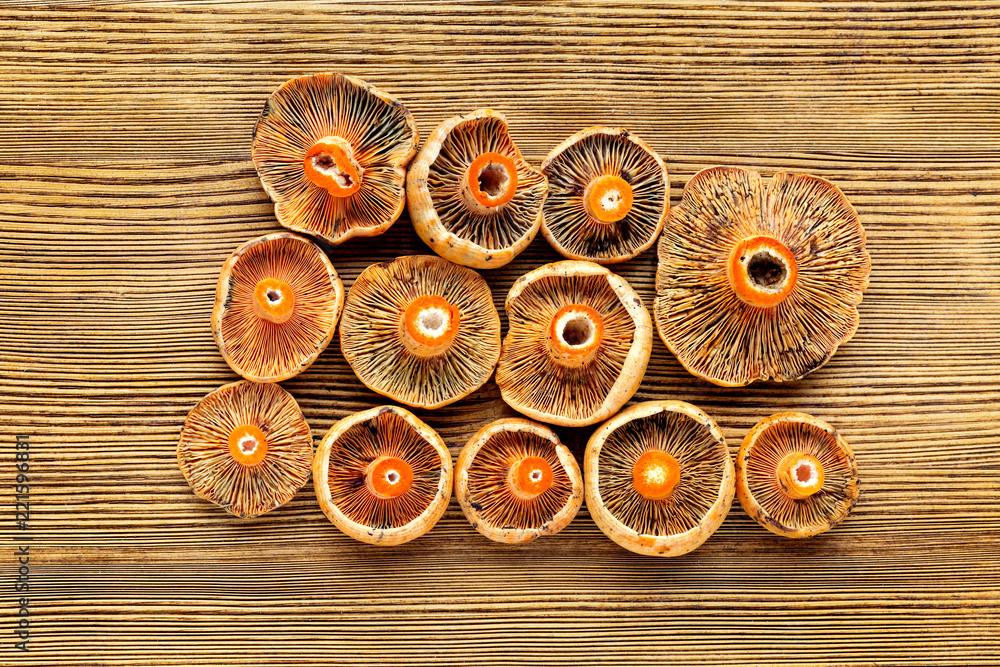 Saffron milk cap on a wooden table lay flat. Background, texture with ...