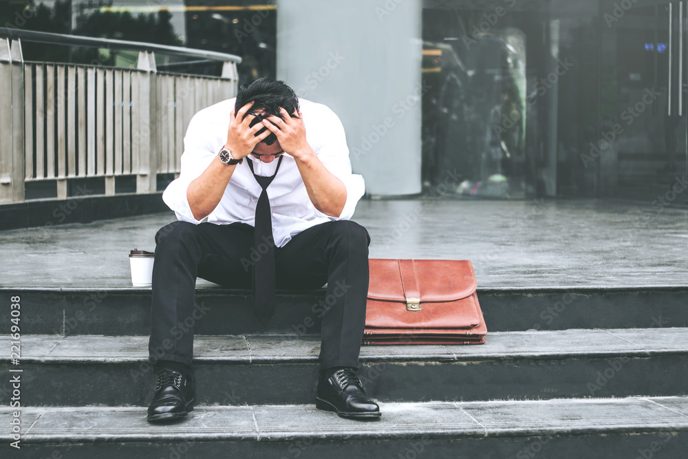 Unemployed Tired or stressed businessman sitting on the walkway after ...