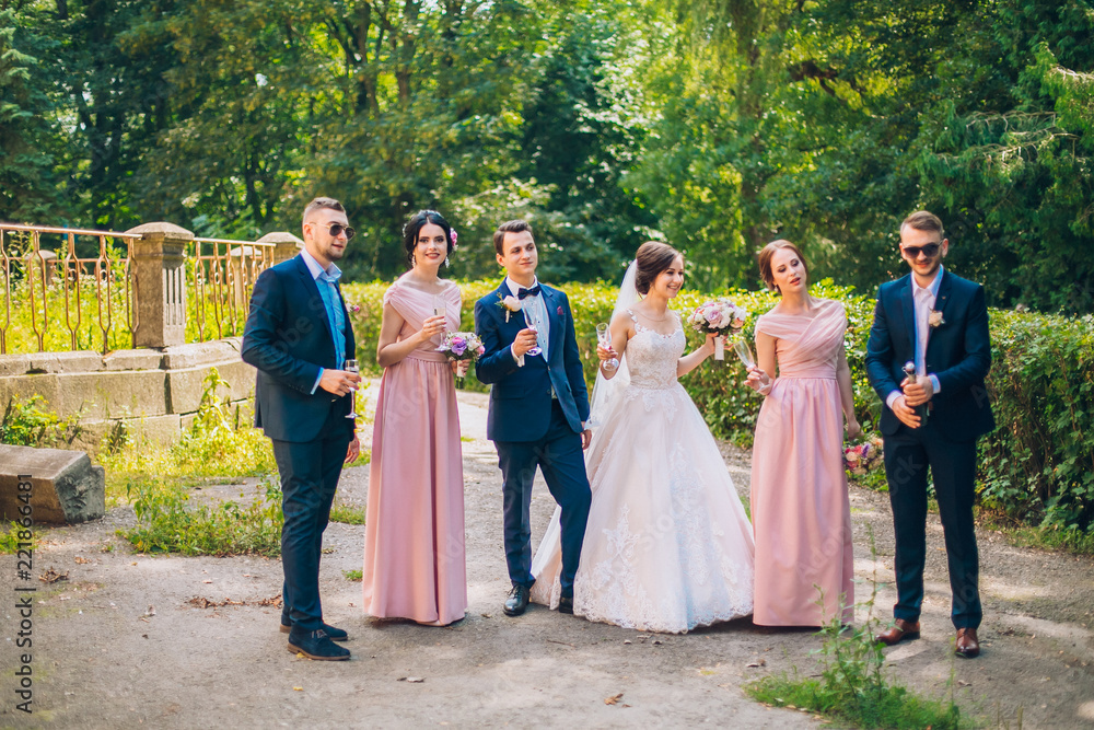 Bride and groom with happy groomsmen and bridesmaids having fun and ...