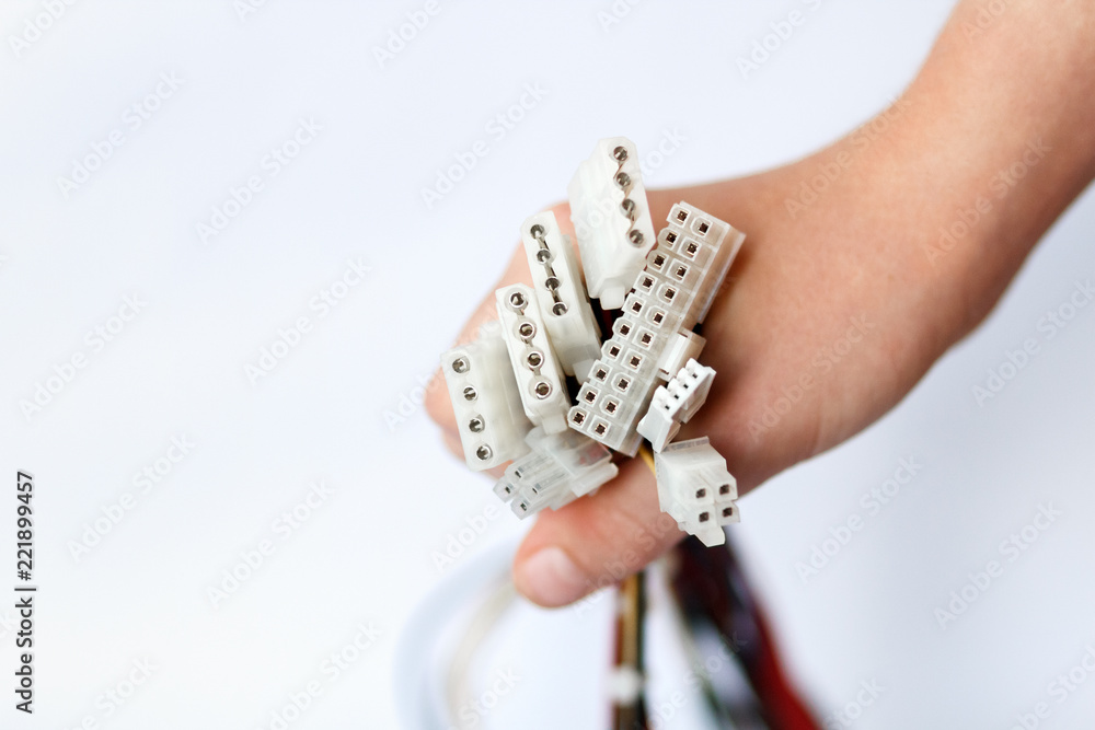 hand holds power cables from power supply unit on white background, PC ...