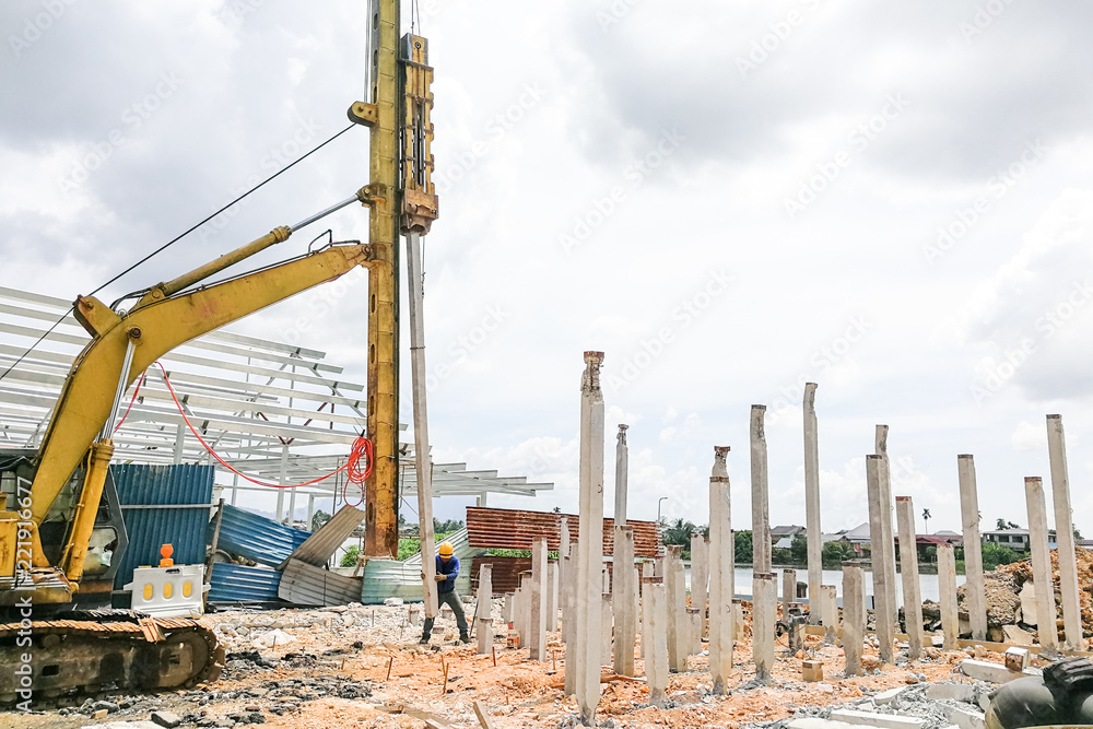 Worker carrying out ground piling work at construction site Stock Photo ...