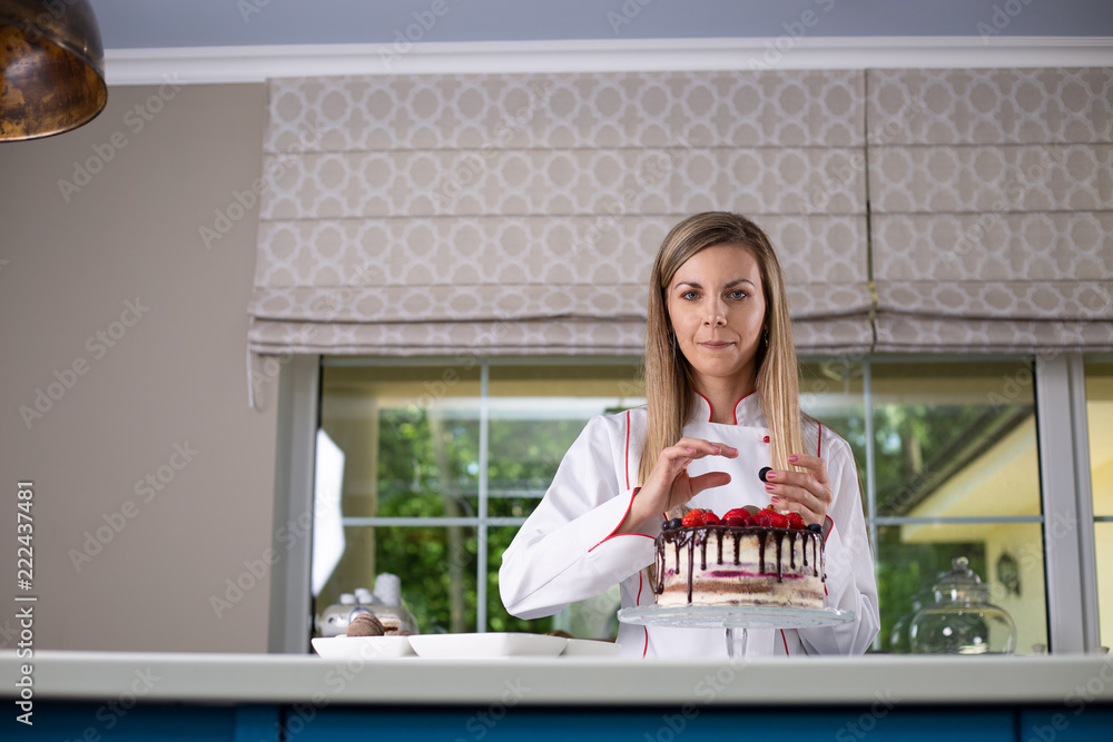 Beautiful female confectioner rondon standing in a modern kitchen ...