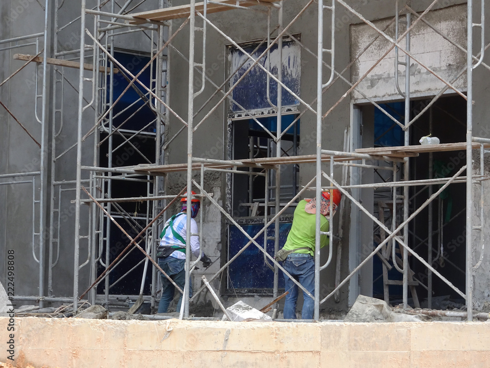 Brick wall plastered by construction workers using the cement plaster ...