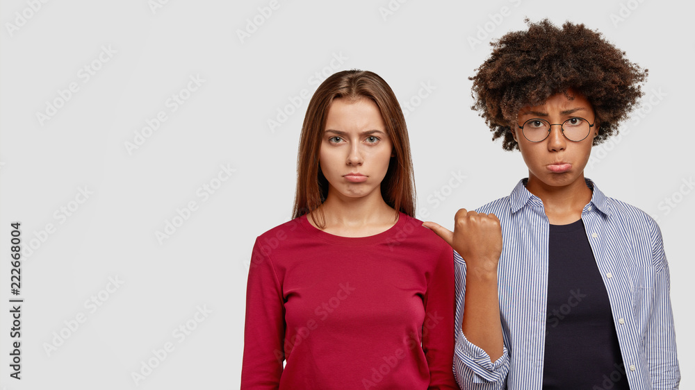 Horizontal shot of offended diverse women purse lips in dissatisfaction ...