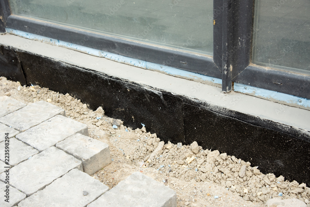 Waterproofing house foundation with spray on tar Stock Photo | Adobe Stock