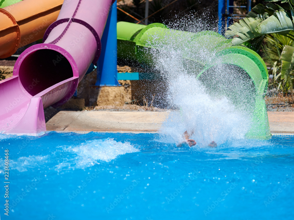 Colorful plastic water slides in waterpark. There are splashes left by ...