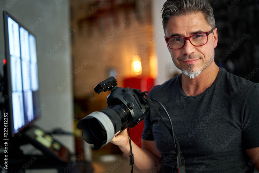 Older man holding photo camera smiling Stock Photo | Adobe Stock