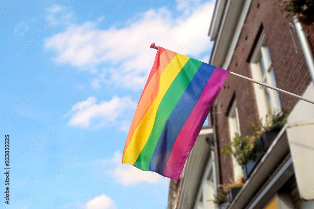 Rainbow LGBT flag against the blue sky, symbol of tolerance and ...