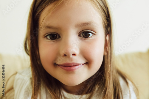 Close-up of cute little girl looking at camera and smiling. People ...