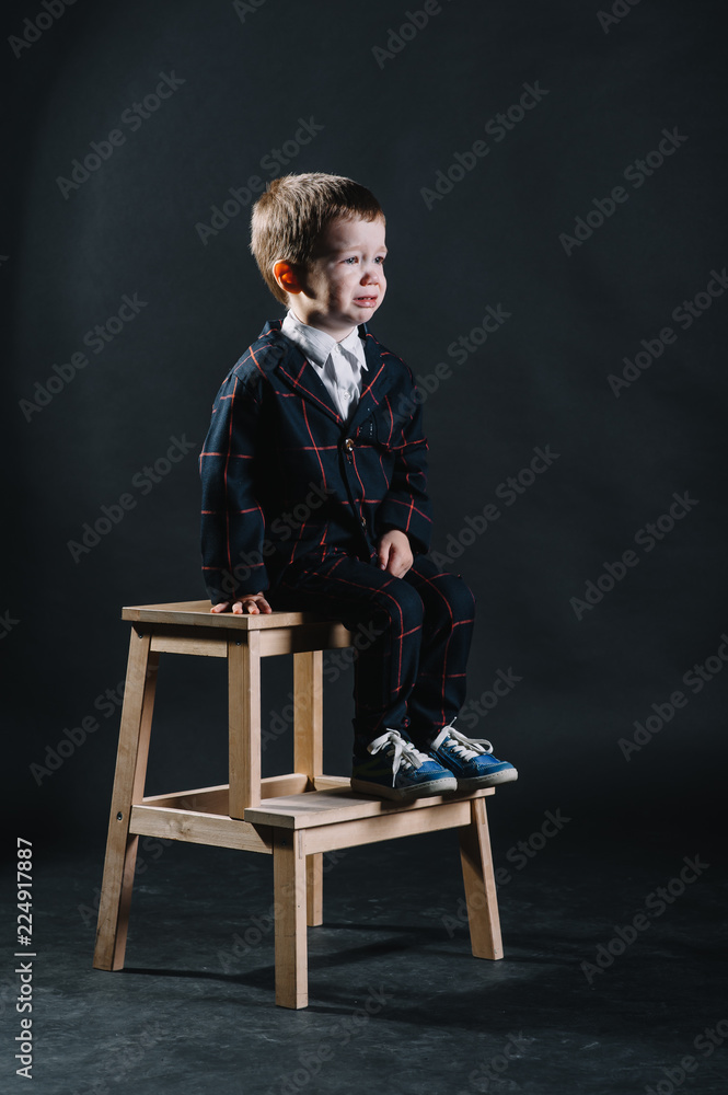 Cute boy cries. Kid cries on a playground. A child rubbed his eyes. A ...