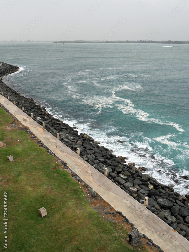 Paved walkway with borders of rock piles at the seaside of El Morro ...