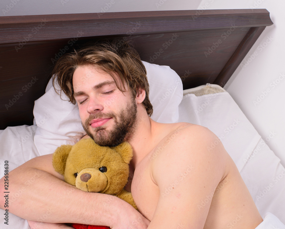 Man handsome guy relaxing bed hug teddy bear toy. Sweet memories from ...