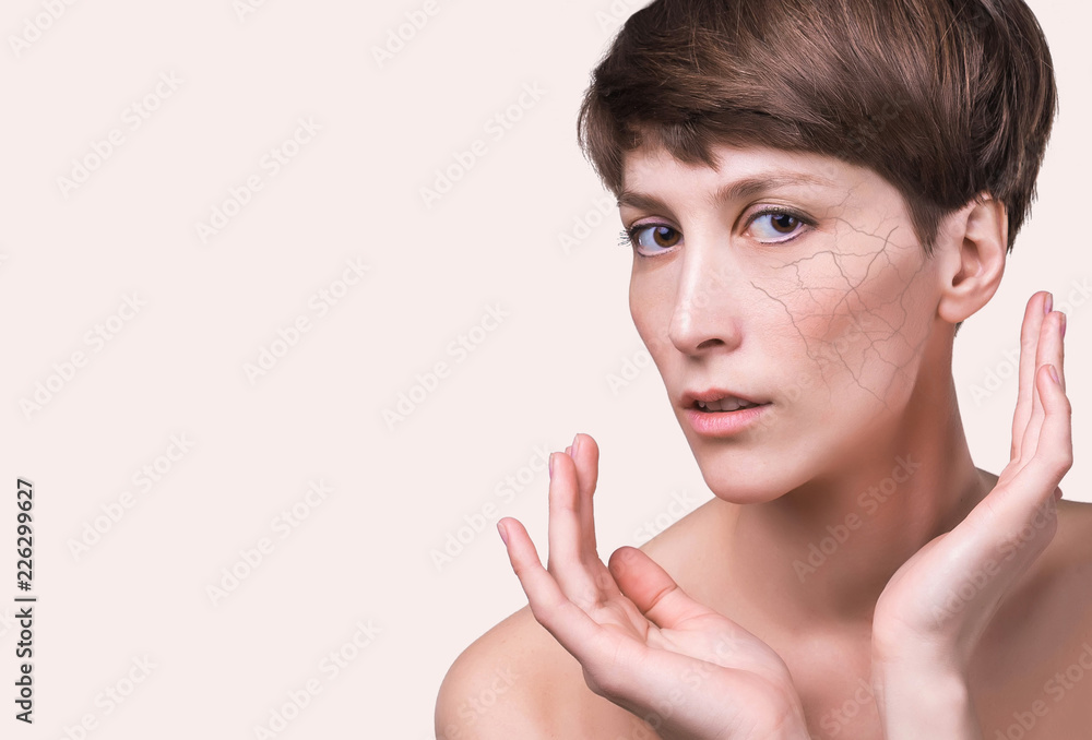 Woman face covered with cracked earth texture- symbol of dry skin ...
