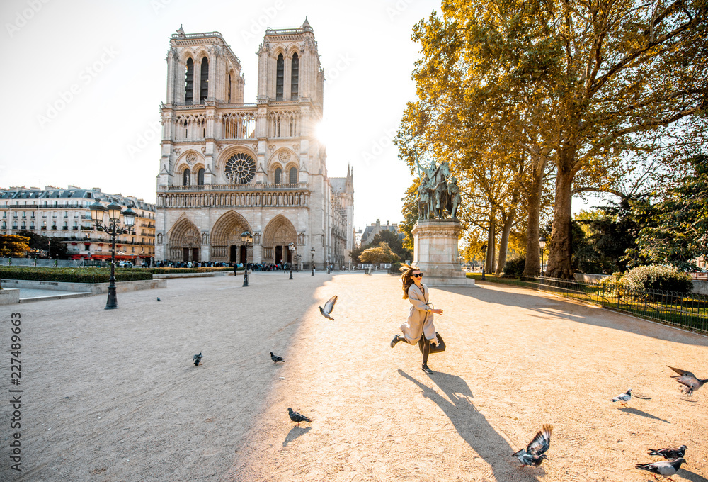 Morning view on the famous Notre-Dame cathedral with woman running on ...