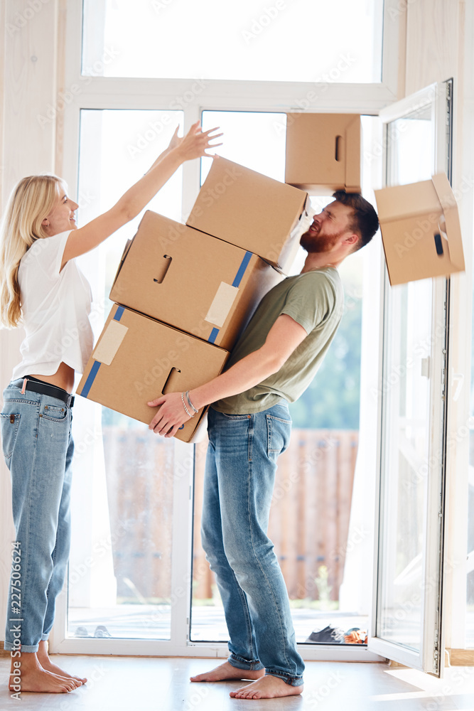 Young man Falling Stack Of Cardboard Boxes Over back In House while ...