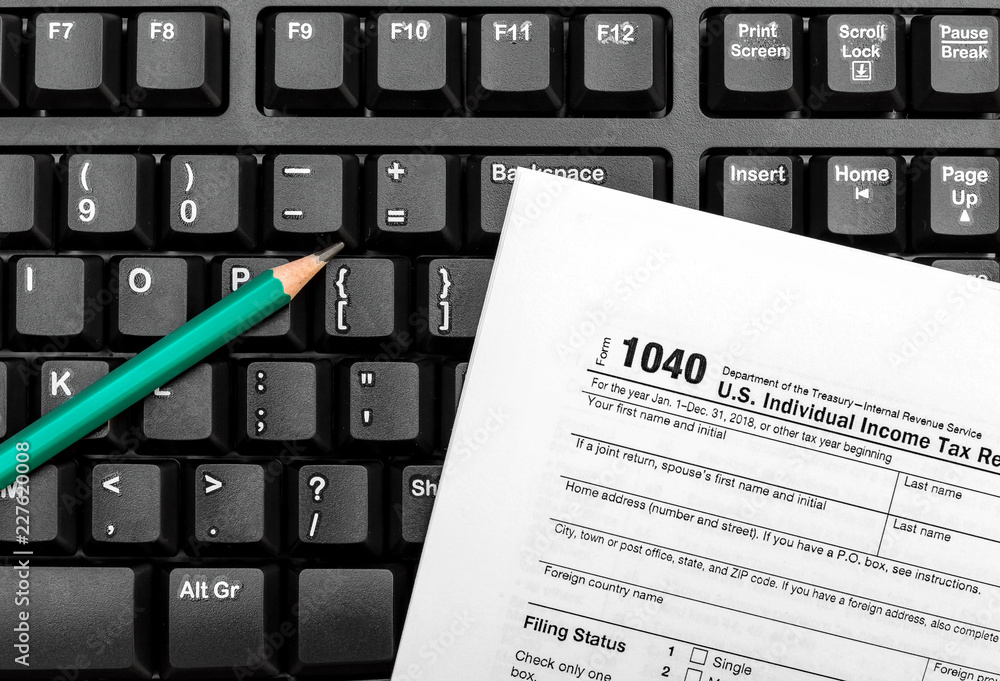 Tax form 1040 with pencil on black keyboard. Top view. Close up. Stock ...