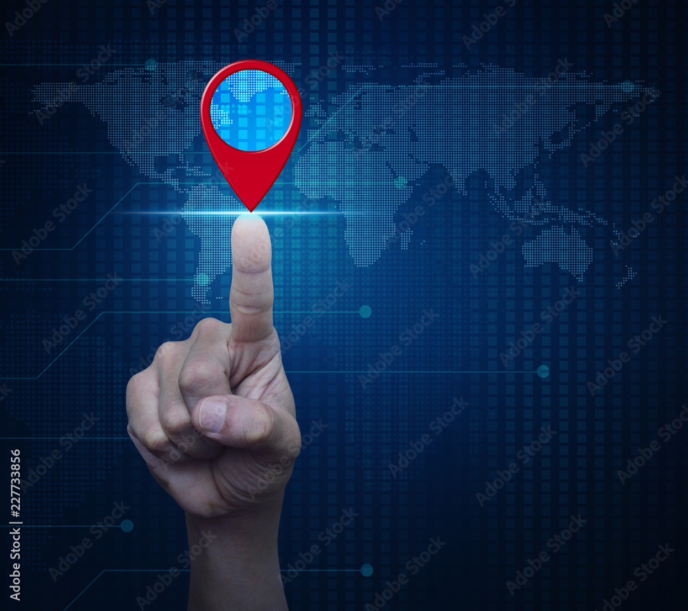 Hand pressing map pin point location button over digital world map ...