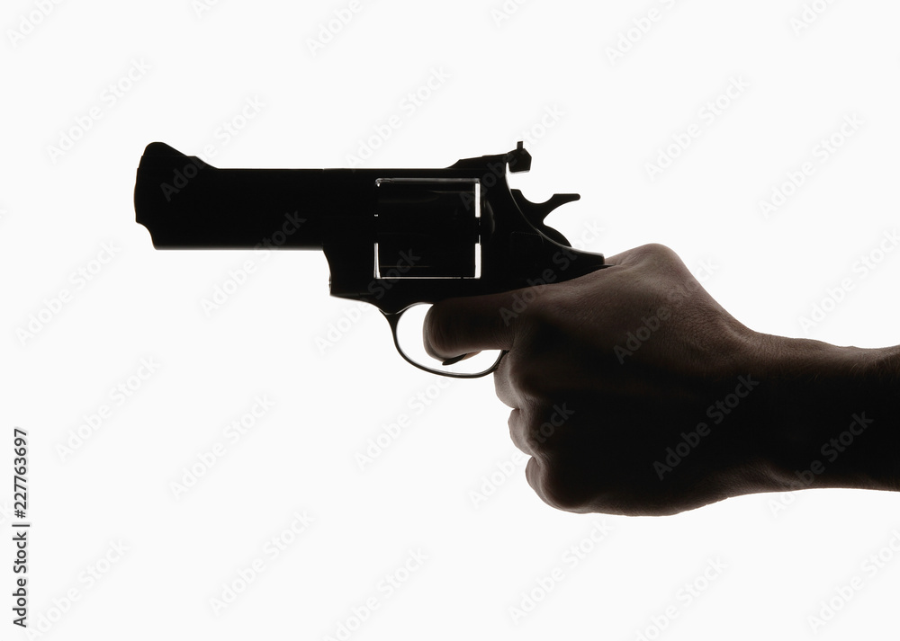 HAND HOLDING REVOLVER IN SILHOUETTE ON WHITE BACKGROUND Stock Photo ...