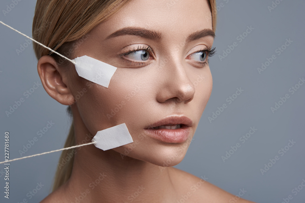 Improving the skin. Calm young lady looking into the distance while ...