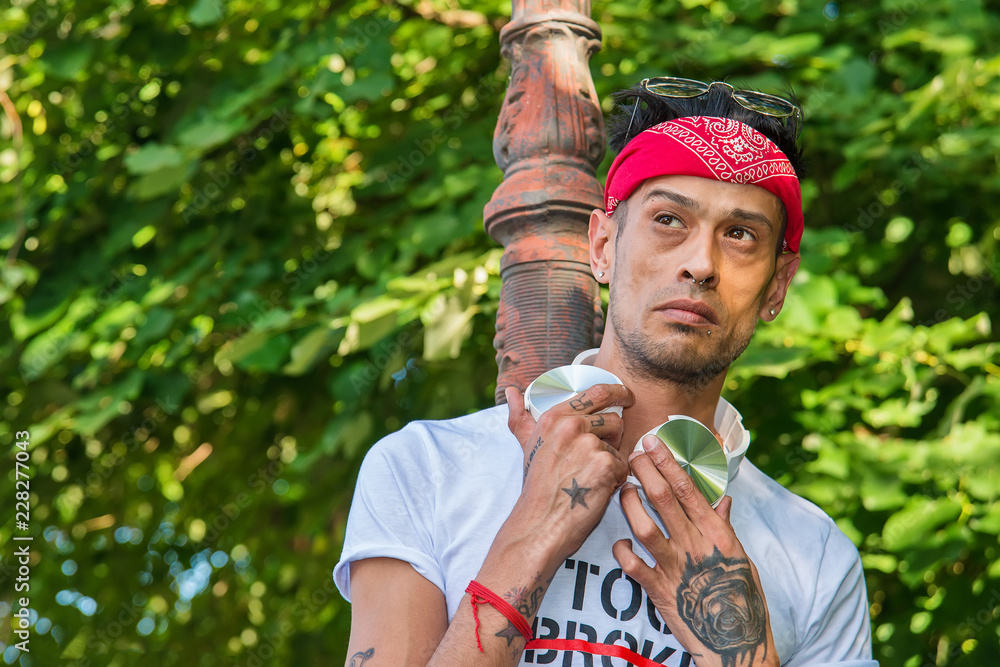 Extravagant (hipster) male model in nature. The guy poses in front of ...