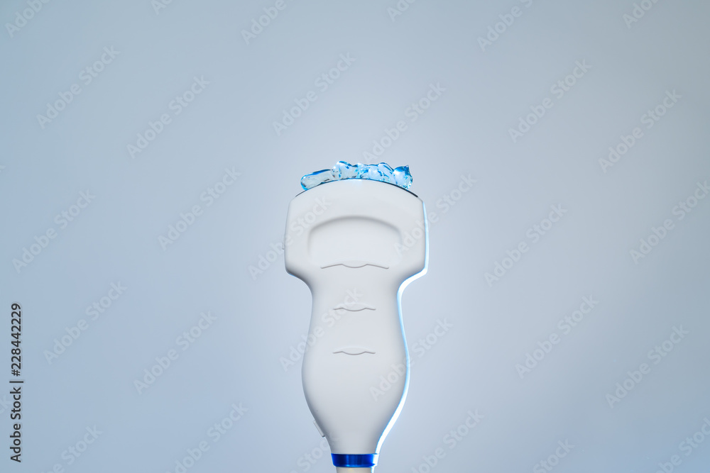 Ultrasound probe with sonographic gel high key blue light background ...