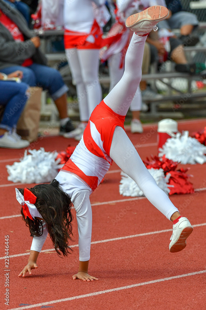 Little girl cheerleader at a youth football game Stock Photo | Adobe Stock