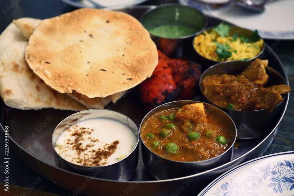 Assorted Indian food set in tray, tanduri chicken, naan bread, yoghurt ...