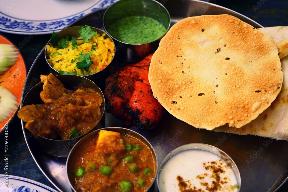 Assorted Indian food set in tray, tanduri chicken, naan bread, yoghurt ...