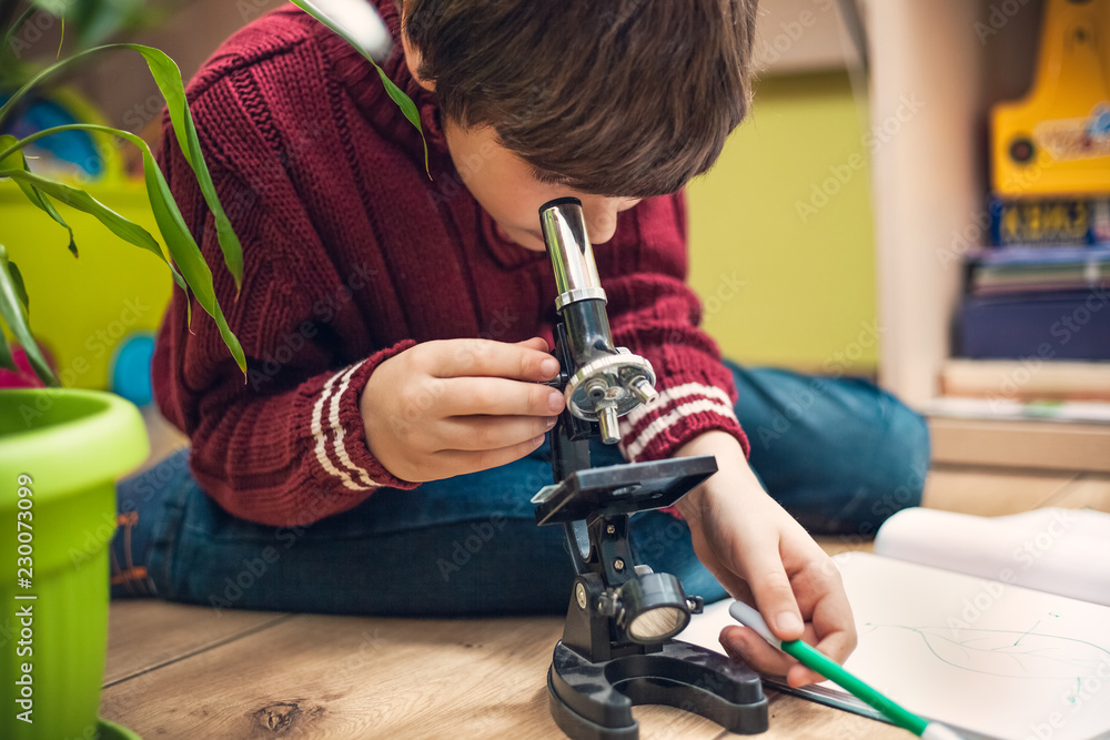 Closeup portrait of little boy using microscope on biology lesson Stock ...