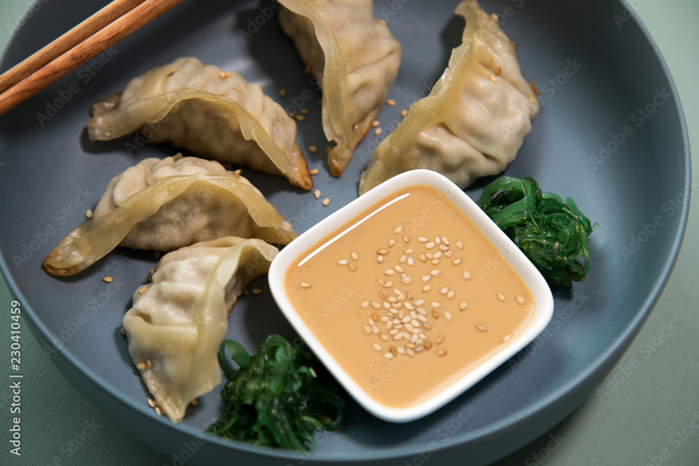 Gebratene asiatische Dim Sum Teigtaschen mit Wakame Algen Salat und ...