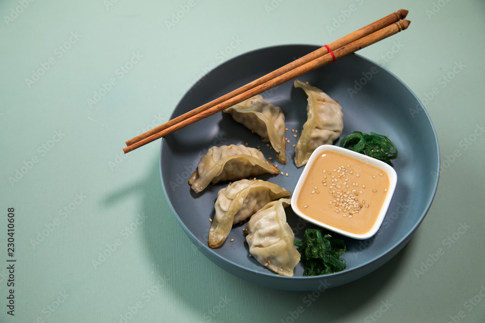 Gebratene asiatische Dim Sum Teigtaschen mit Wakame Algen Salat und ...