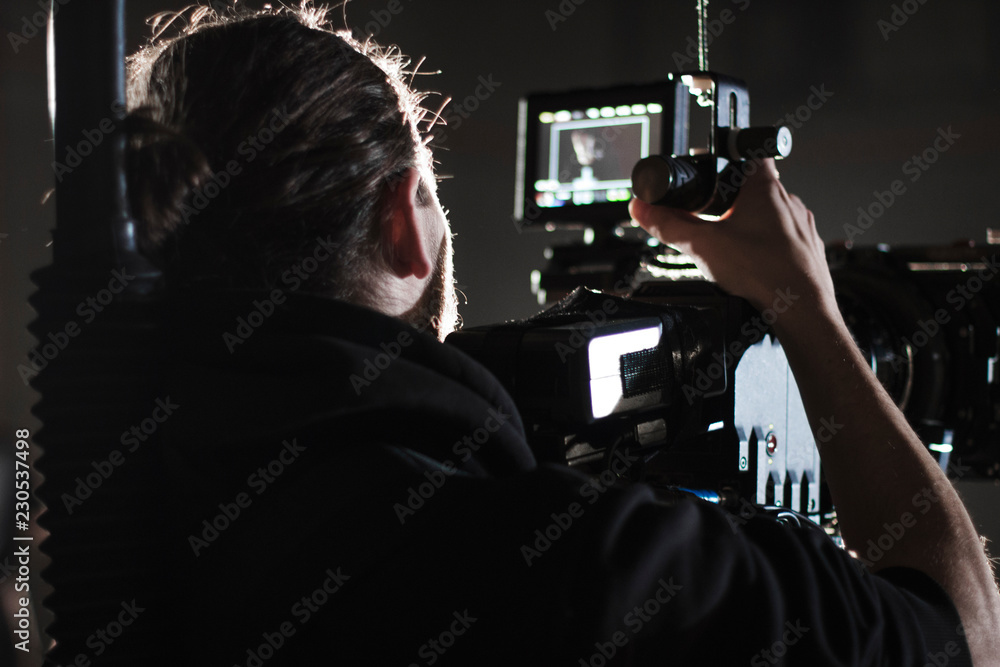 Professional videographer holding camera mounted on easy rig ...