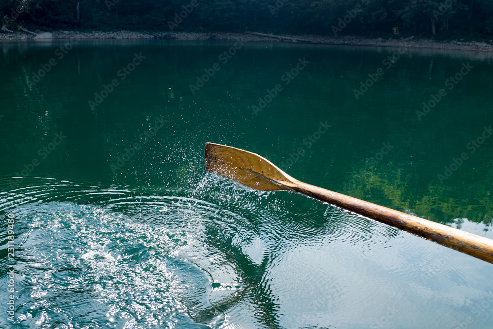 Photo Stock Oar of boat touching water and causing splash and ripples ...