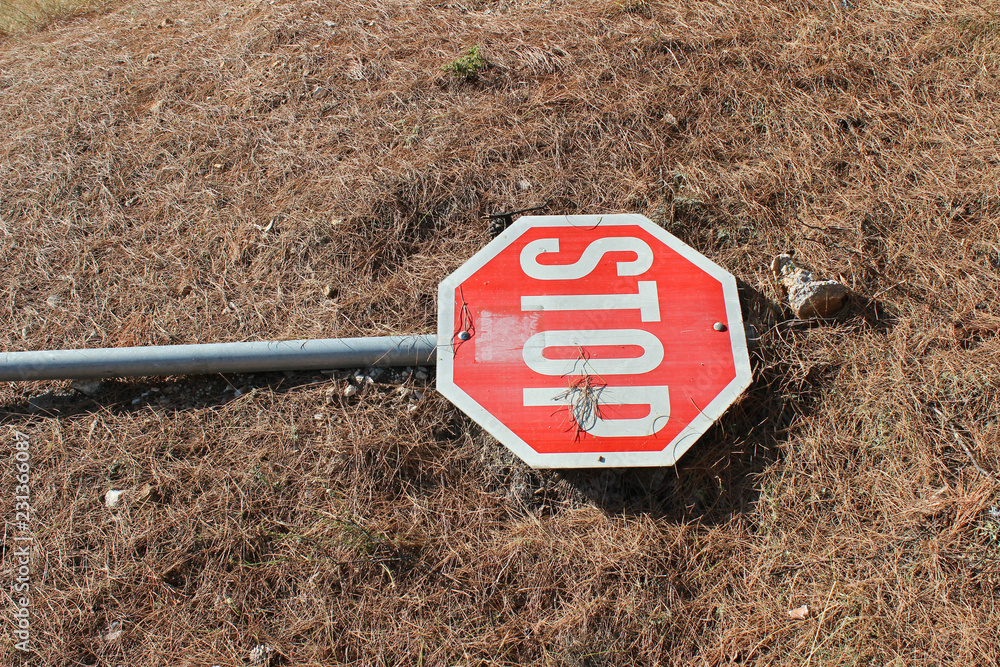 Foto de Stock Broken stop traffic sign on the ground concrete base ...