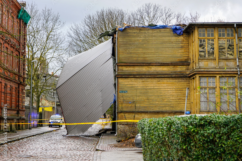 Yellow police tape surrounds this building following a severe storm ...
