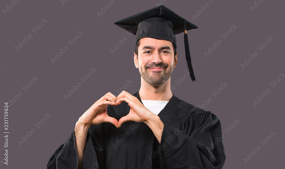 Man on his graduation day University making heart symbol by hands ...