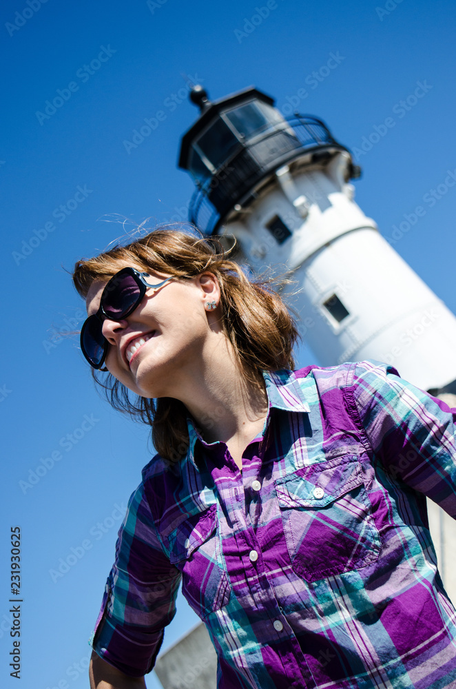 Artistic angle of a woman standing and smiling in front of Canal Park ...