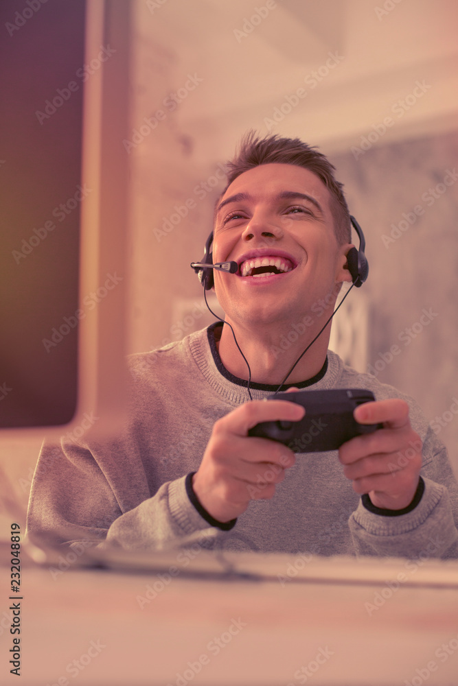 Short haired gamer openly smiling while playing Stock Photo | Adobe Stock