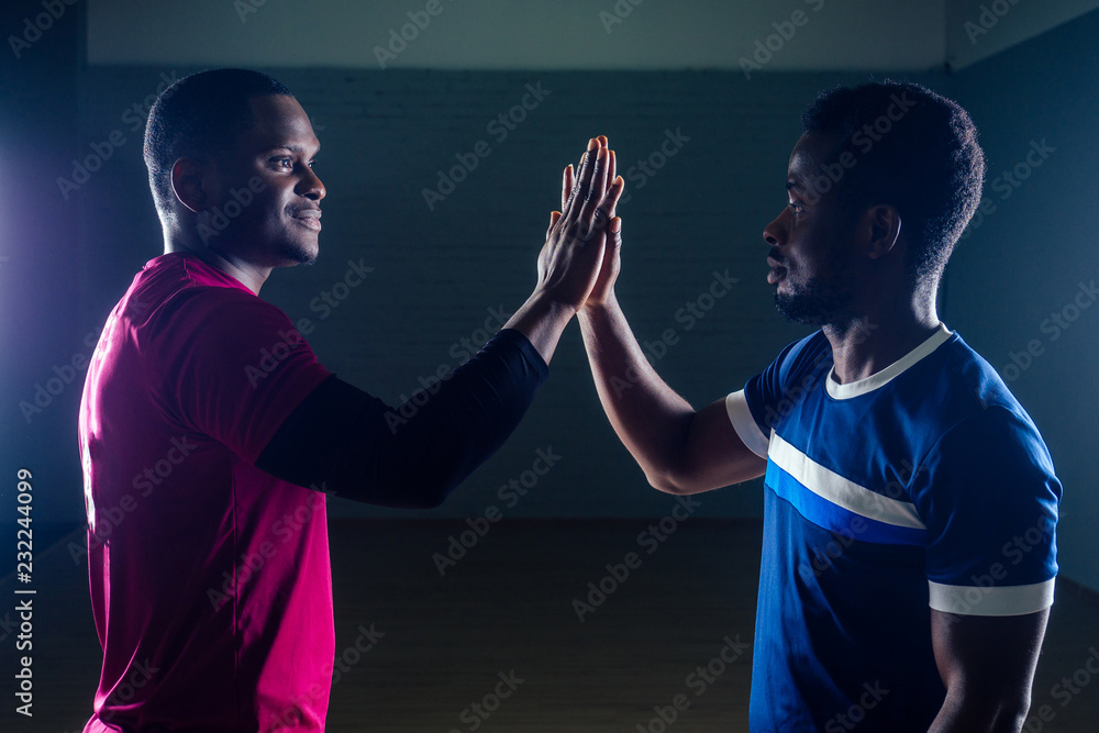 team work two handsome african american sportsman in boxing on a black ...