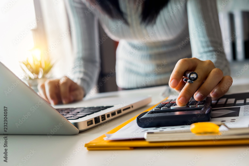 Business women are calculating daily expenses. Stock Photo | Adobe Stock