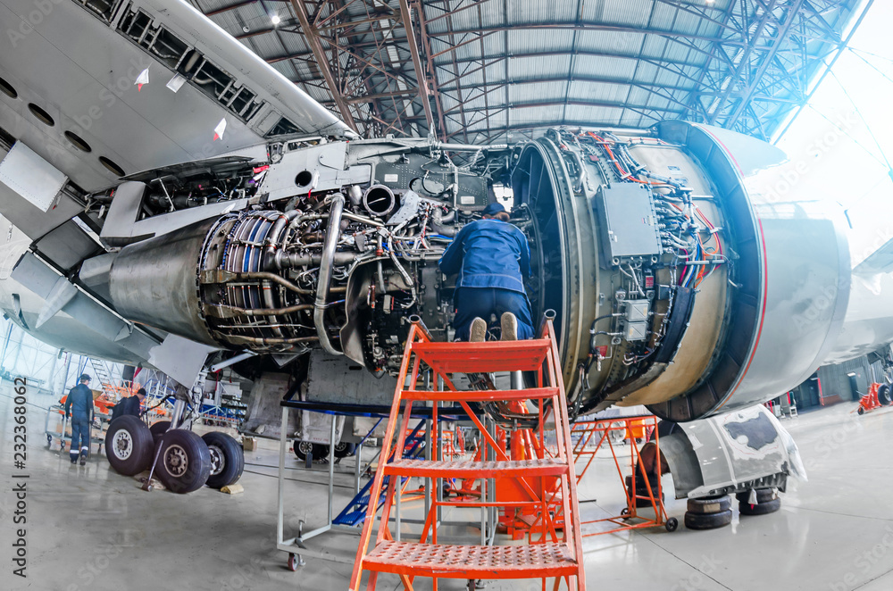 Airplane mechanic diagnose repairs jet engine through open hatch. Stock ...