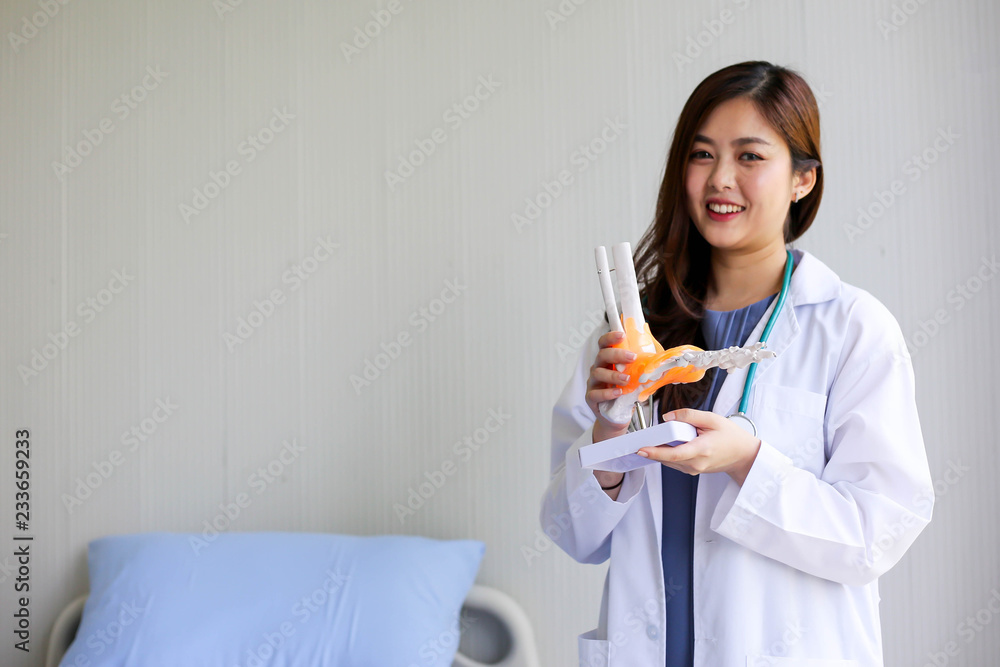 Beautiful woman Doctor is pointing on a bone in the spine the layout of ...