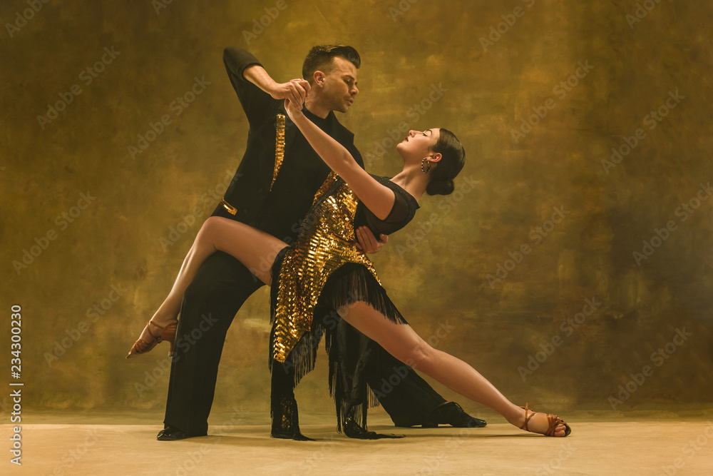 The young dance ballroom couple in gold dress dancing in sensual pose ...