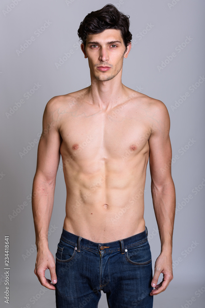 Studio shot of young handsome Brazilian man standing shirtless Stock ...