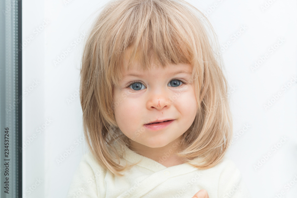 Headshot of adorable cute blonde female child looking at camera with ...
