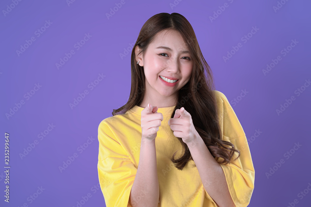 Korean woman greeting by point finger to her friend, yellow t-shirt ...
