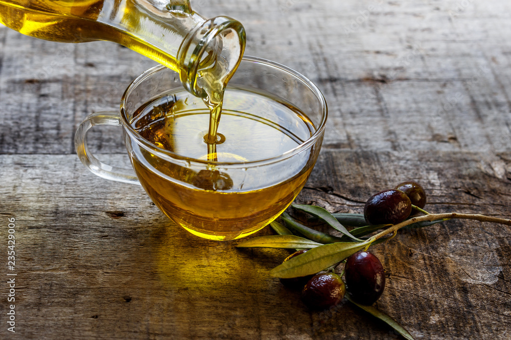 Olive oil pouring into glass bowl Stock Photo | Adobe Stock